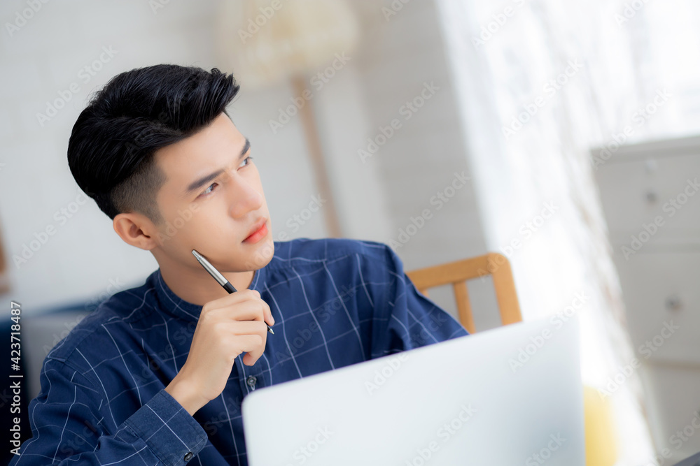 Young asian business man planning working and using laptop computer on ...