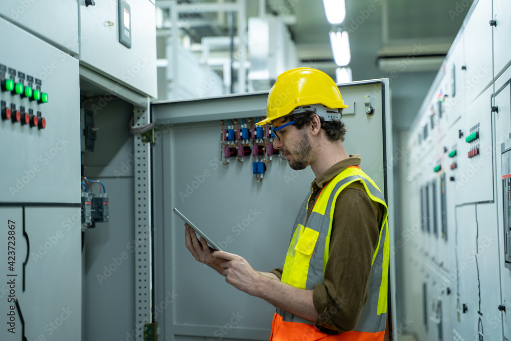 Electrical engineers use digital tablet checking in power plant control ...