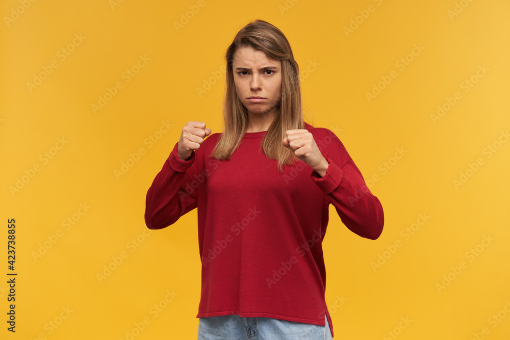 Girl with warlike look, showing her muscles, her power, stands in a ...