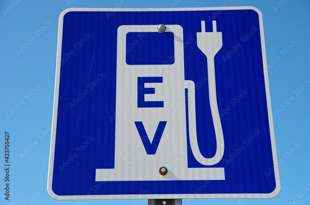 EV charging station sign against blue sky Stock Photo | Adobe Stock