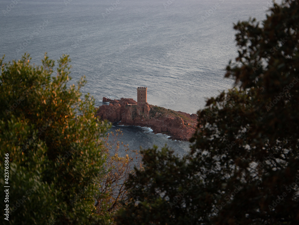 an old lookout tower stands directly in a sea. old historical prison ...