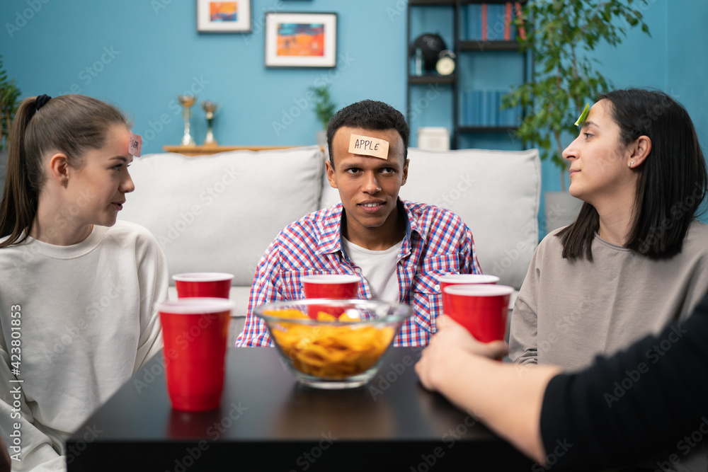In the Living Room Diverse Group of Fun Loving Friends Playing Who am I ...