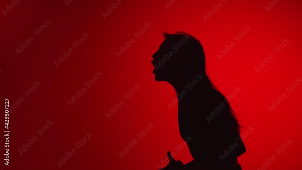 Black silhouette of crazy female shouting shaking middle finger. Shot ...