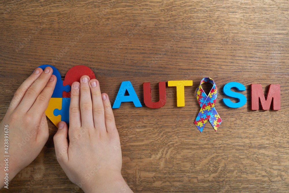 Autistic boy hands holding heart shapeed puzzle with word autism and ...