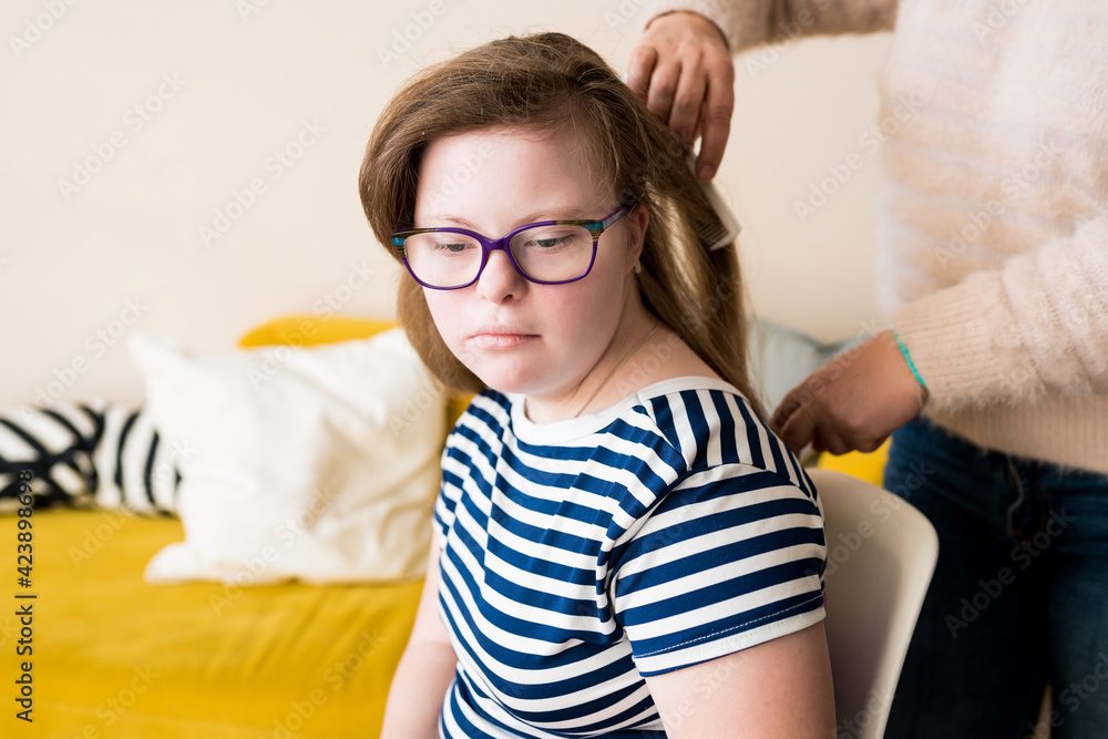 Close-up of mother s hand tying the kid hair in ponytail at home. Mom ...