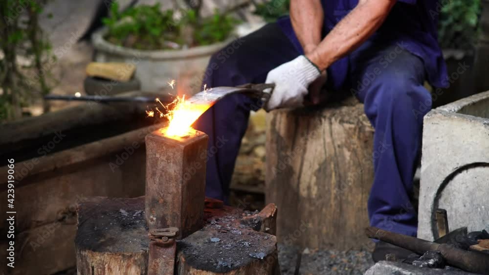 The sparks produced by the ancient forging. Old metal forming. Creating ...