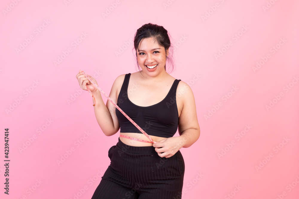 Fat woman with body measures the isolated pink background. Overweight ...