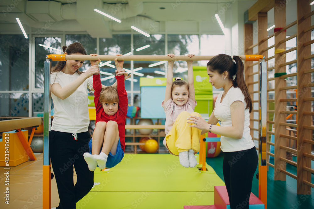 Kids doing pull up exercises in gym at kindergarten or elementary ...