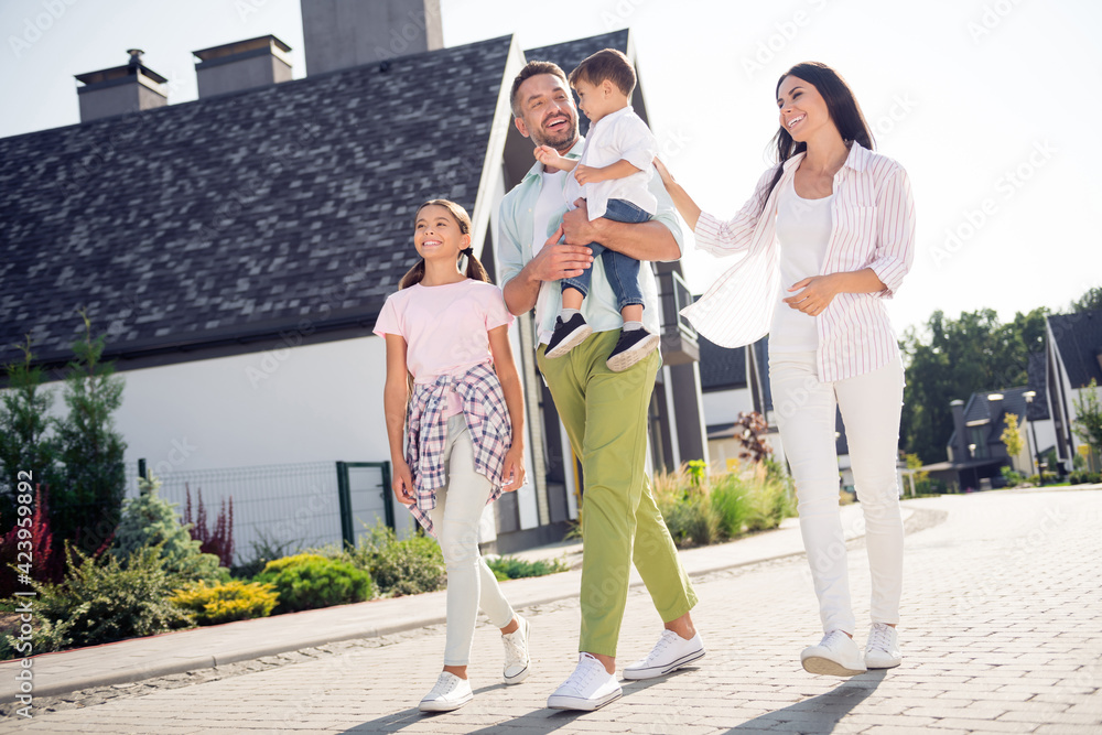 Full length body size view of four cheery people family strolling with ...