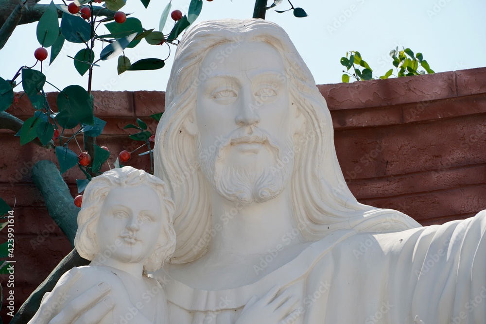 Jesus statue standing and blessing with both the hands against blue sky ...