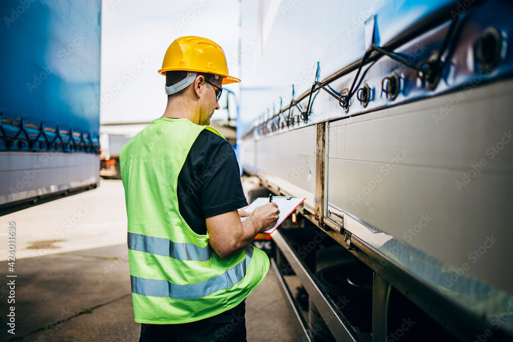 Professional male industrial truck driver with yellow protective helmet ...