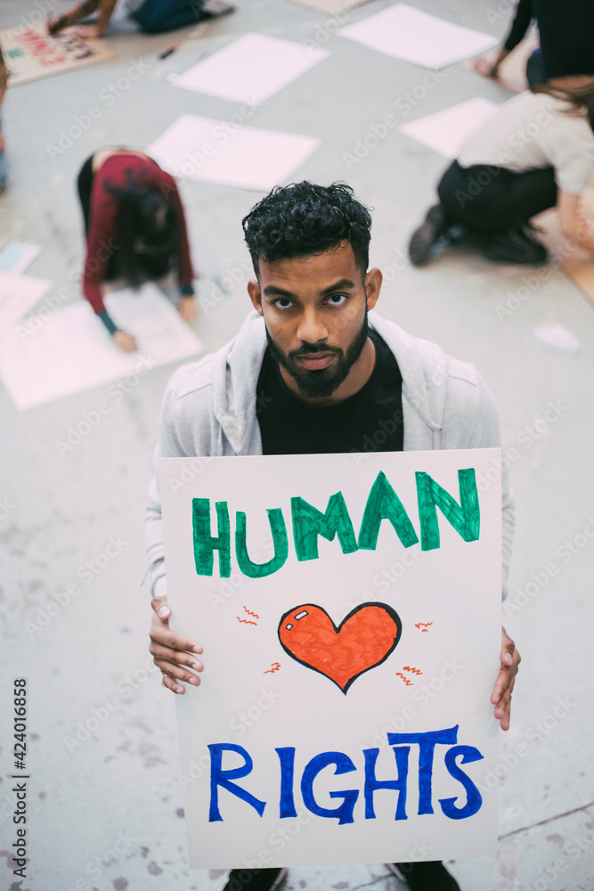 Male activist holding human rights poster during social issues Stock ...
