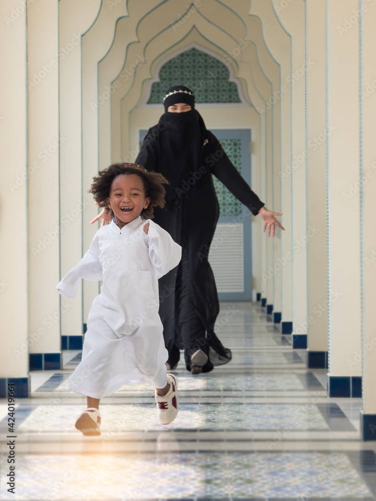 Cute little Muslim boy running with big smile on the face and mother ...