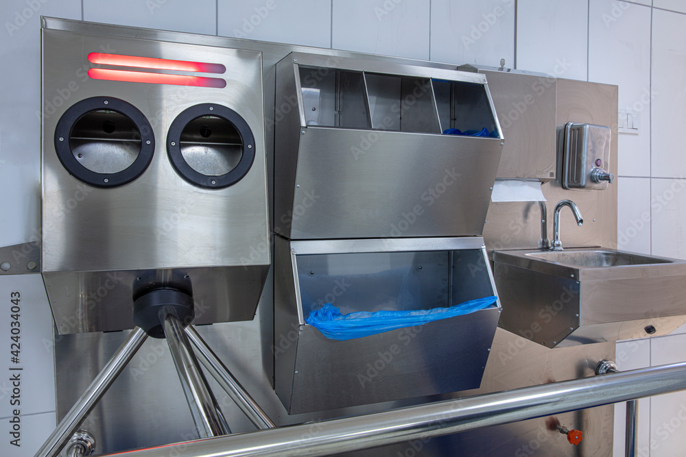 Hand hygiene station with turnstile gate and sanitizer before entering ...