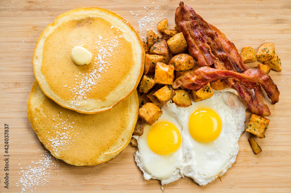 Diner style slam breakfast. Two eggs sunny side up, bacon, hash browns ...