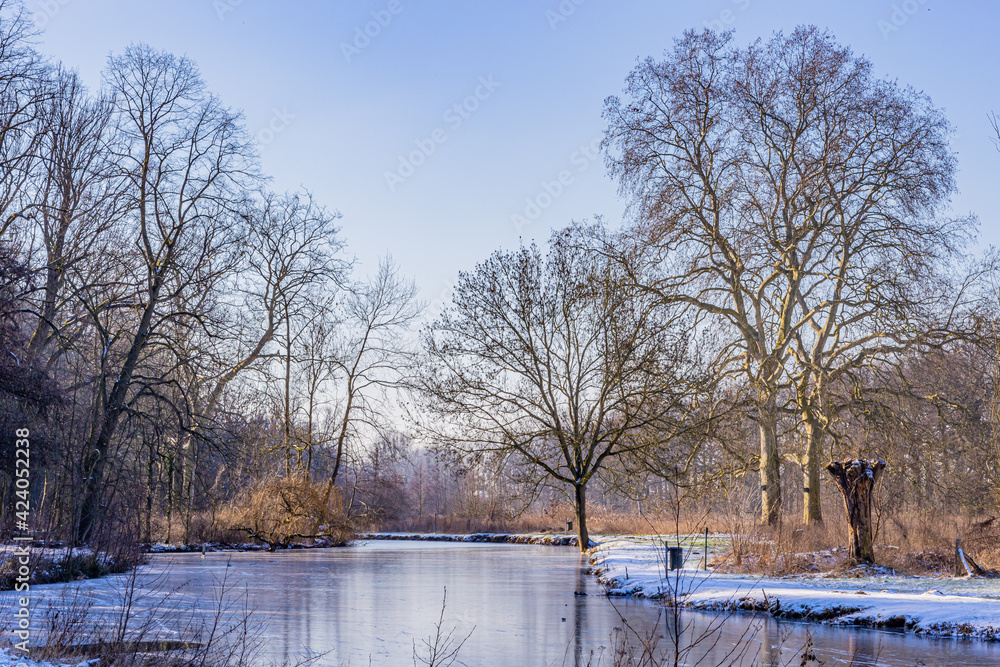 Winter landscape with a pond with its frozen waters, frost and snow ...