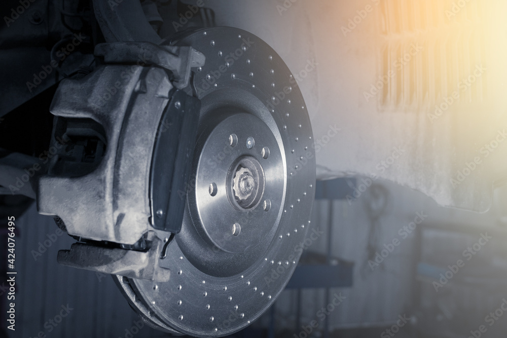 Installation of new perforated brake discs and pads on a modern auto in ...