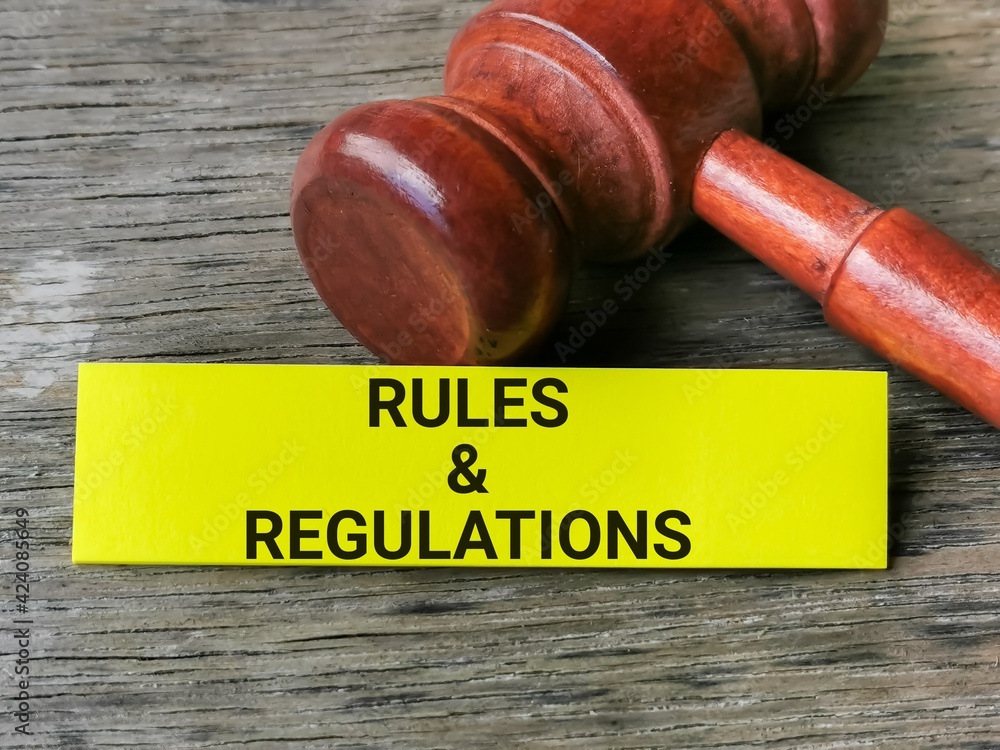 Phrase RULES AND REGULATIONS written on sticky note with gavel. Stock ...