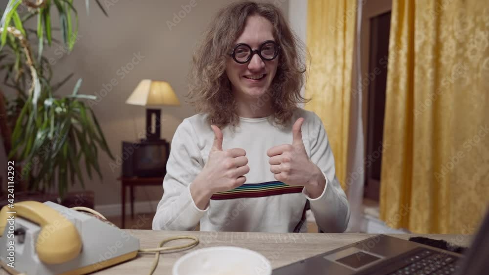 Satisfied young nerd man hanging up retro telephone and showing thumbs ...