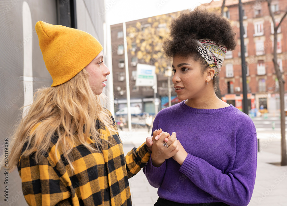 two women of different races, holding hands, down the street Stock ...