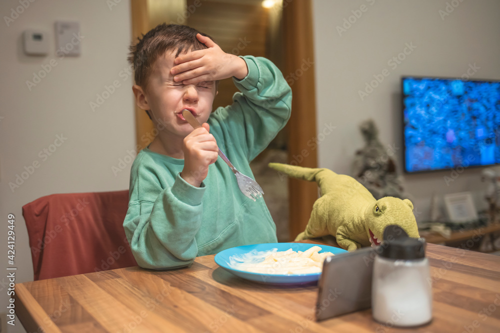 Boy unhappy with his lunch. Child boy eating boring food. Little boy is ...