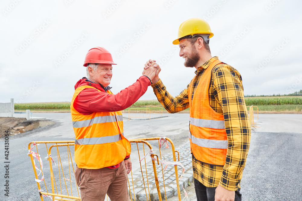 Two construction workers greet each other with a handshake Stock Photo ...