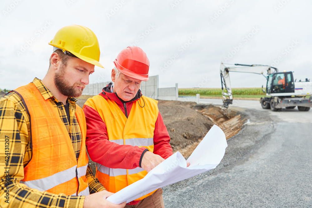 Construction workers team during construction planning with floor plan ...