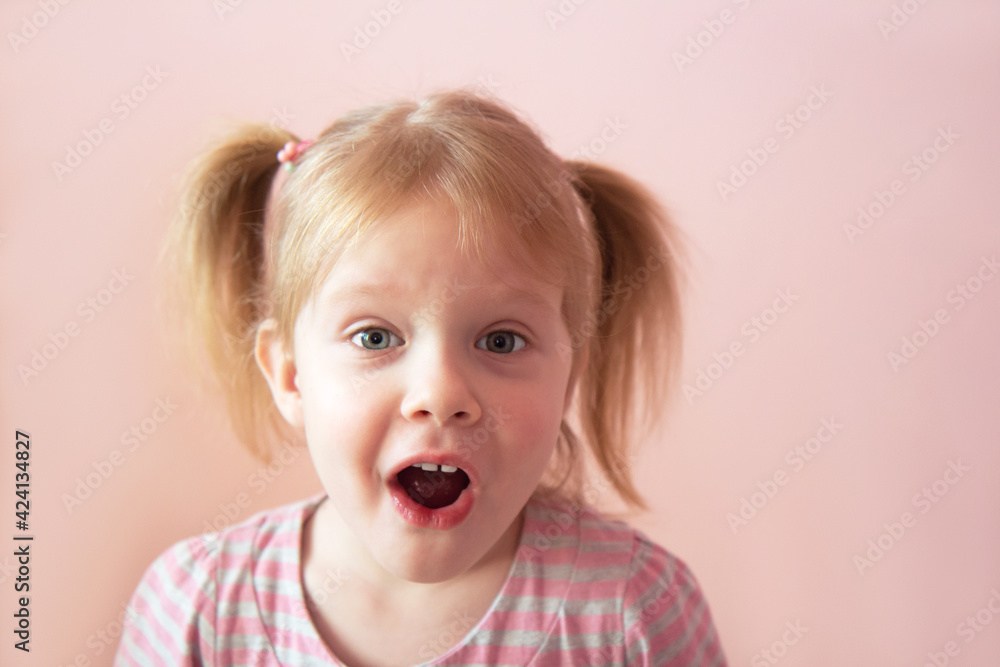 Beautiful naughty little girl with a surprised face on a light ...