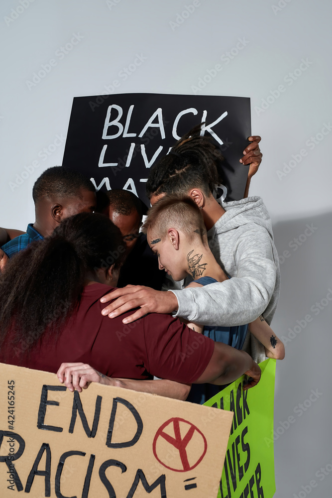 Multiracial people holding anti racist posters while hugging Stock ...