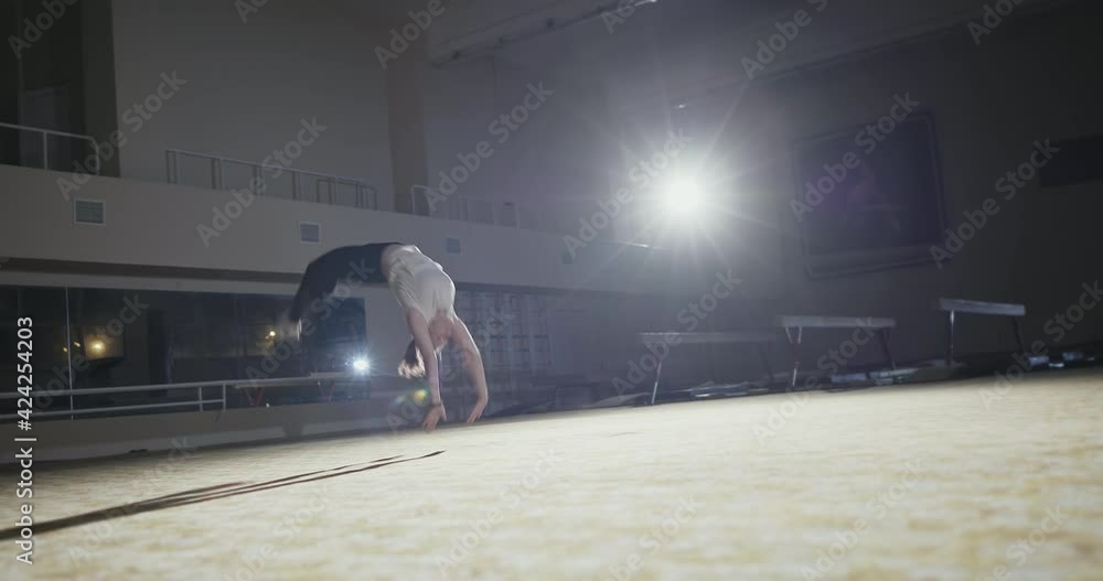 Vidéo Stock Girl gymnast performs somersaults forward in the gym on a ...