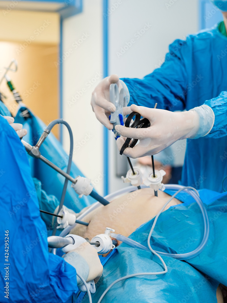 The hands of surgeons in latex gloves and blue uniforms hold special ...