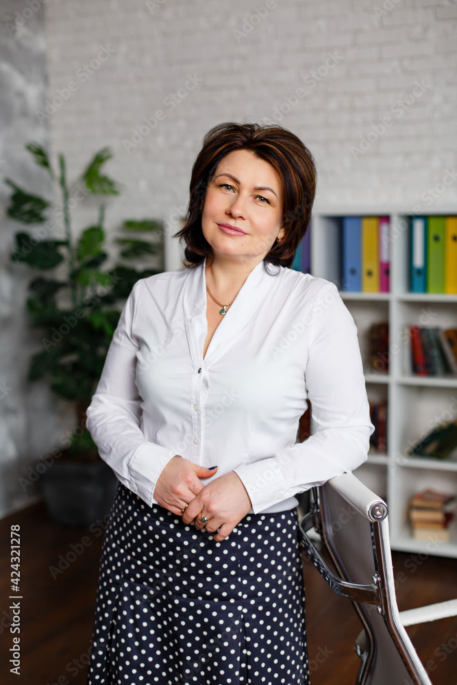 Beautiful middle-aged business woman in an office. Female supervisor at ...