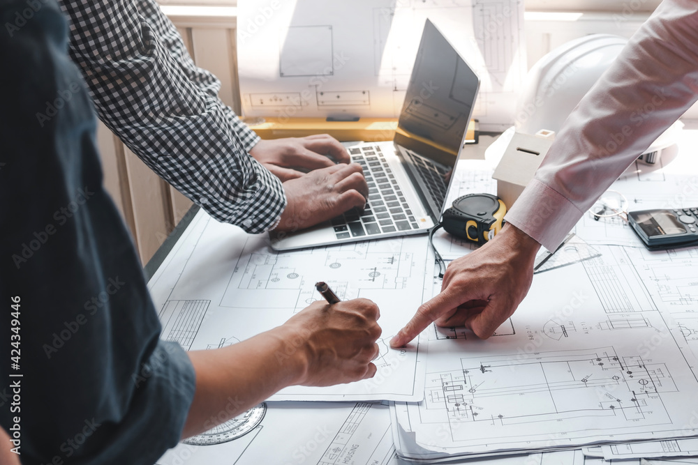 Team work of a group engineering architects pointing blueprint at the ...