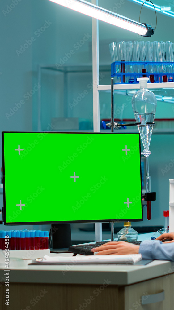 Biochemist sitting at workplace in laboratory using green mock-up ...