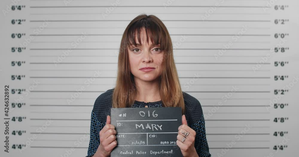 Portrait of adult woman with forelock holding sign for photo in police ...
