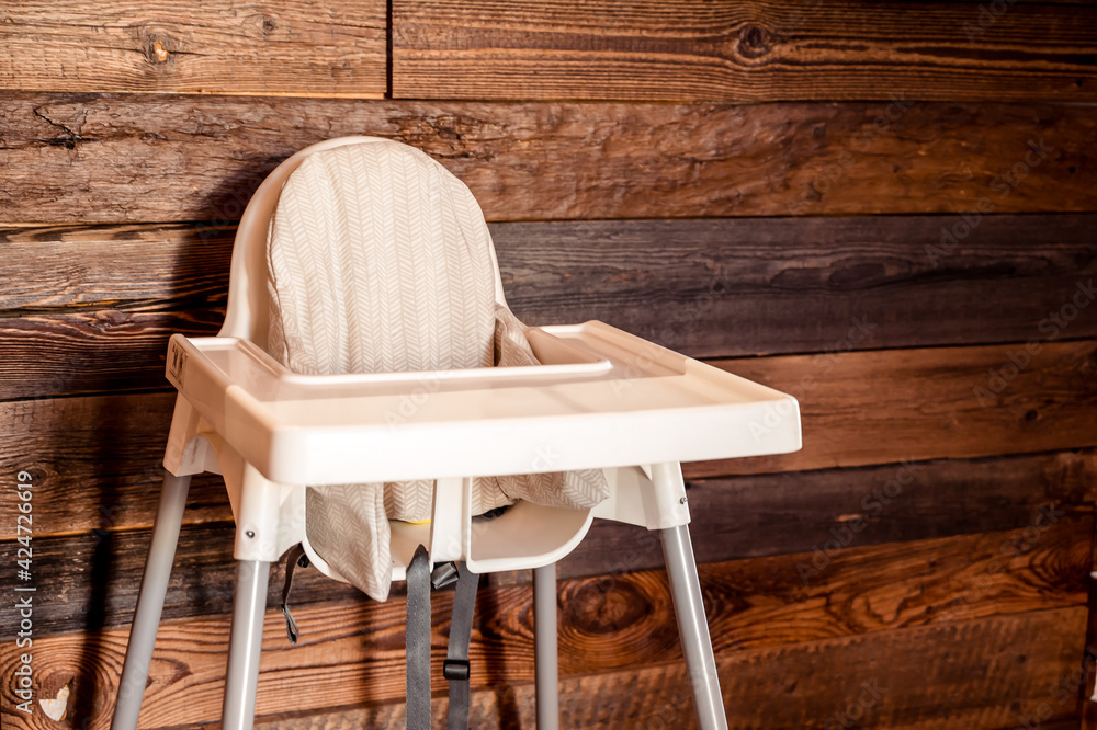 high chair for children in the restaurant. an empty white plastic baby ...