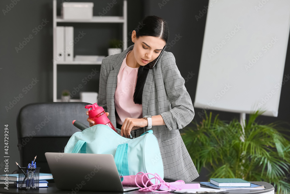 Young businesswoman going to go to gym after working day in office ...