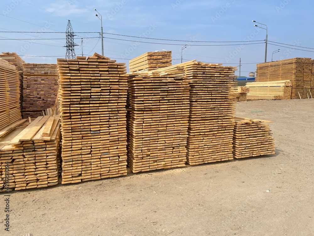 Wooden boards are stored outdoors. Wooden boards, lumber, industrial ...