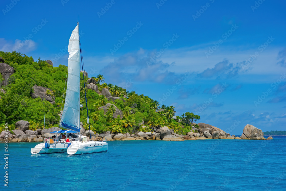 catamaran in a bay in the Seychelles, little Island with palm trees ...