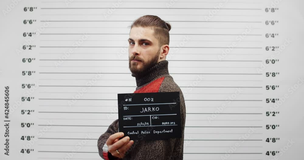 Mugshot of handsome guy turning head and looking to camera while ...