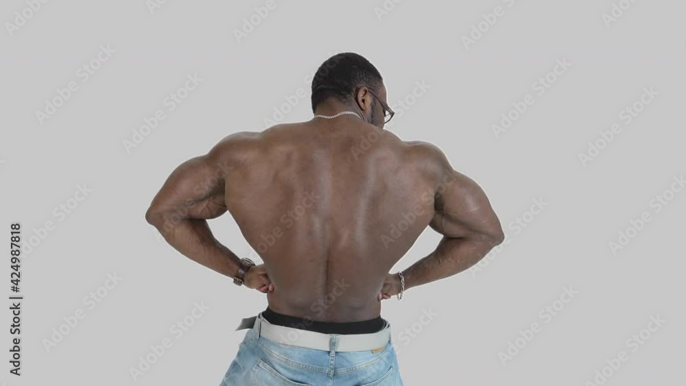 Sportsman with dark skin shows his back muscles. Muscular afro american ...