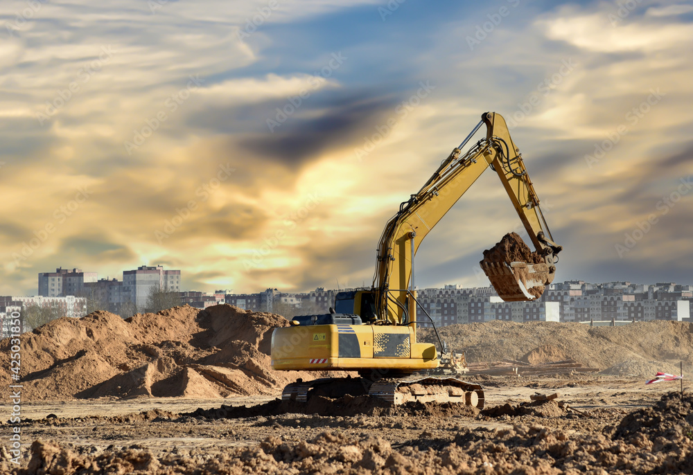 Excavator during earthmoving work at construction site on sunset ...