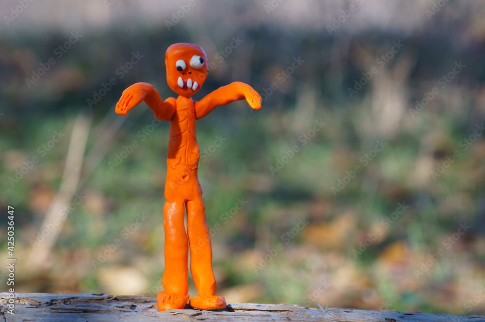 Figure of an orange zombie on a background of leaves. Stock Photo ...