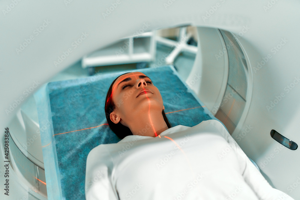 Portrait of a patient lying on CT or MRI, the bed moves inside the ...