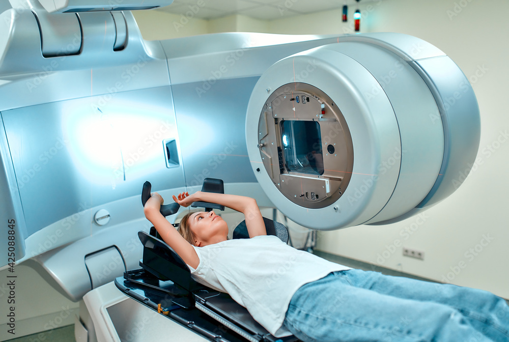 A young woman is undergoing radiation therapy for cancer in a modern ...