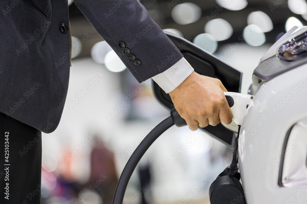 Hand holding Electric car charger. Electric Vehicle EV Charging station ...