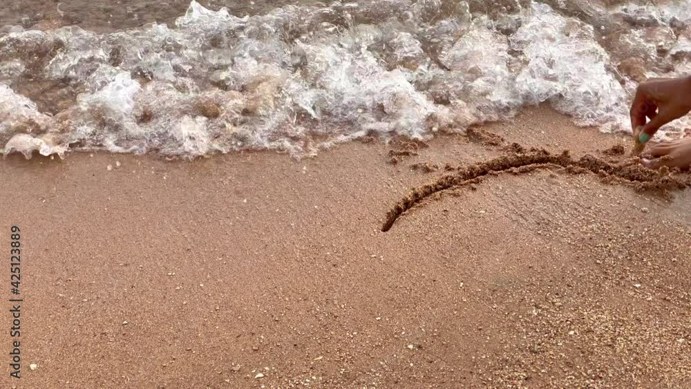 Depression recovery. Young woman drawing sad face on sand and waves ...