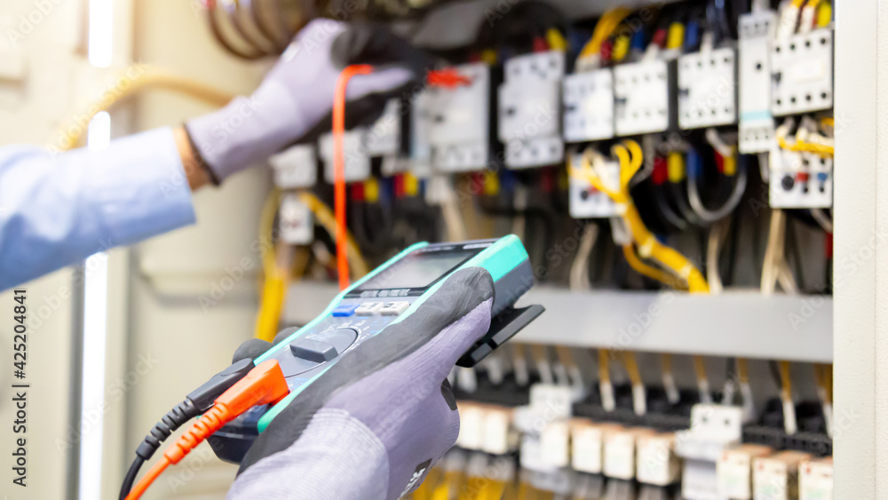 Foto Stock Electrical engineer using digital multi-meter measuring ...