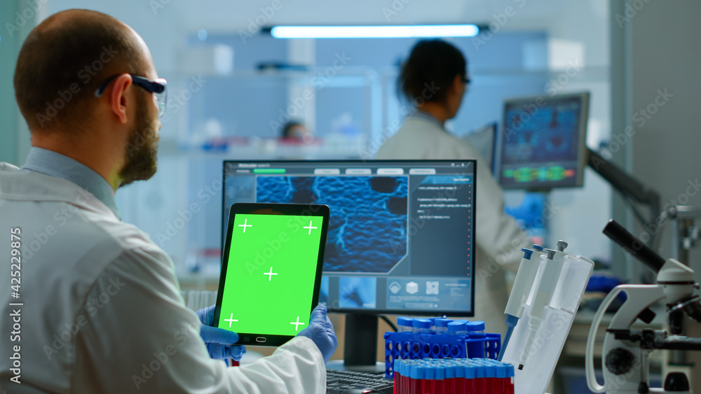 Man doctor holding tablet with green screen in modern equipped lab ...