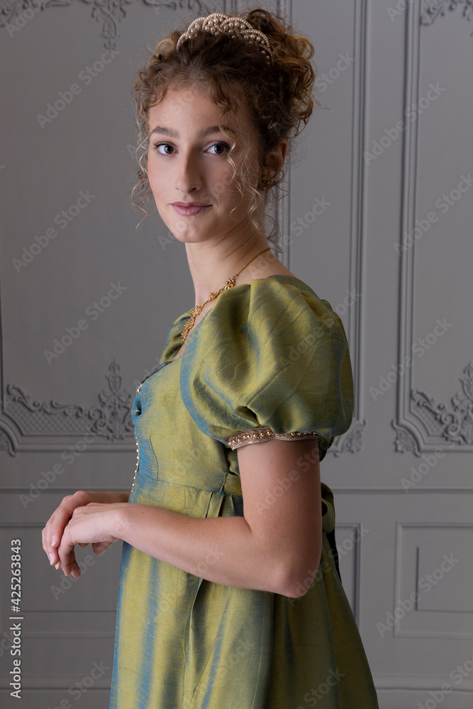 A young Regency woman wearing a green shot silk dress standing against ...
